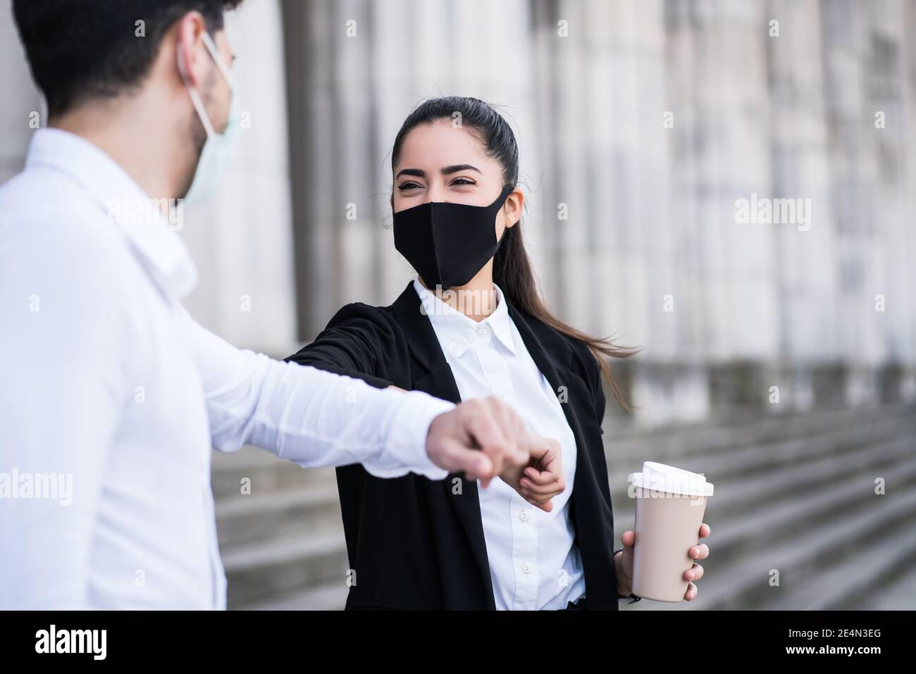 Business people bumping elbows for greeting each other Stock Photo - Alamy