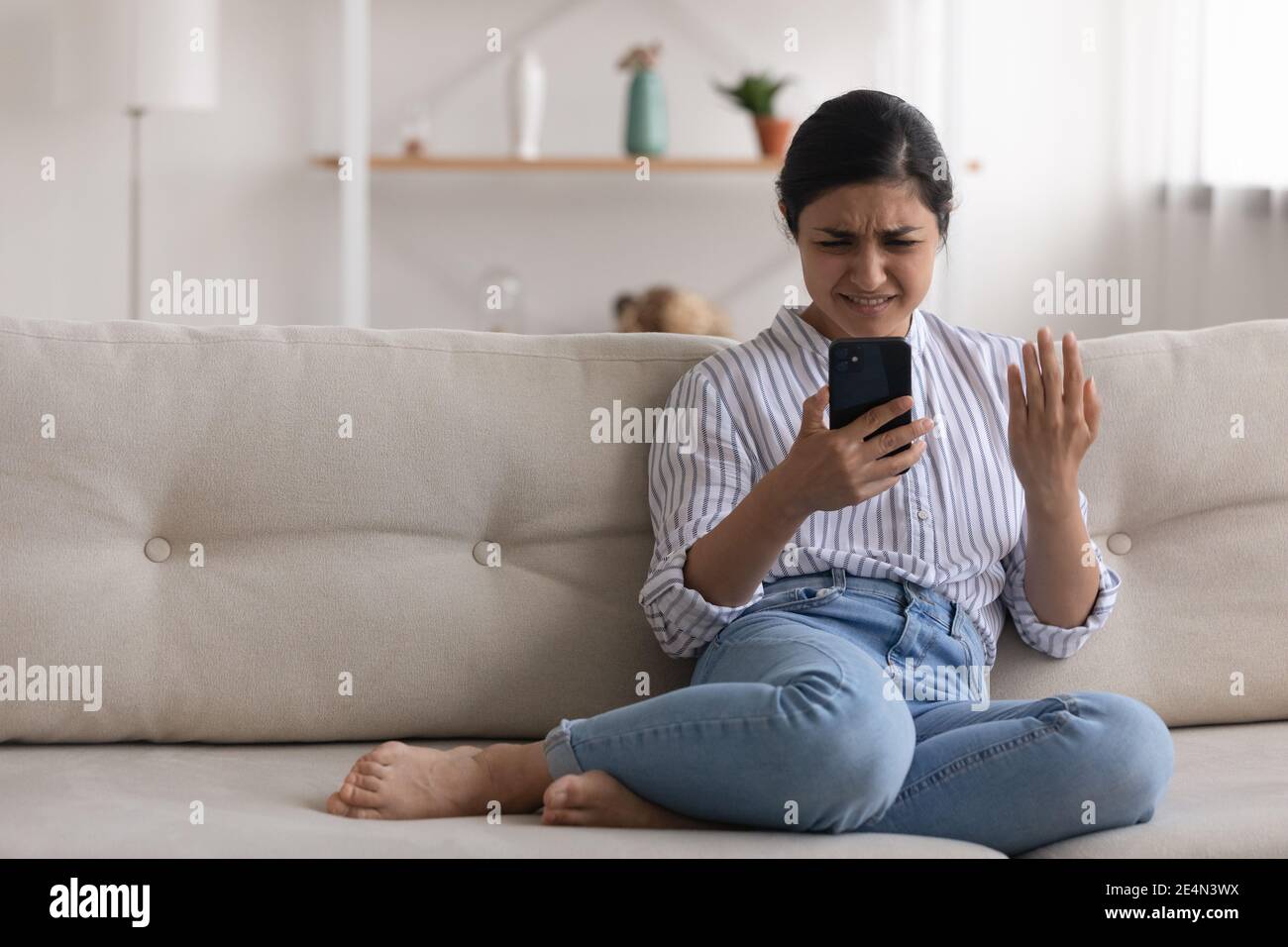 Angry young indian woman read spam message on phone screen Stock Photo ...