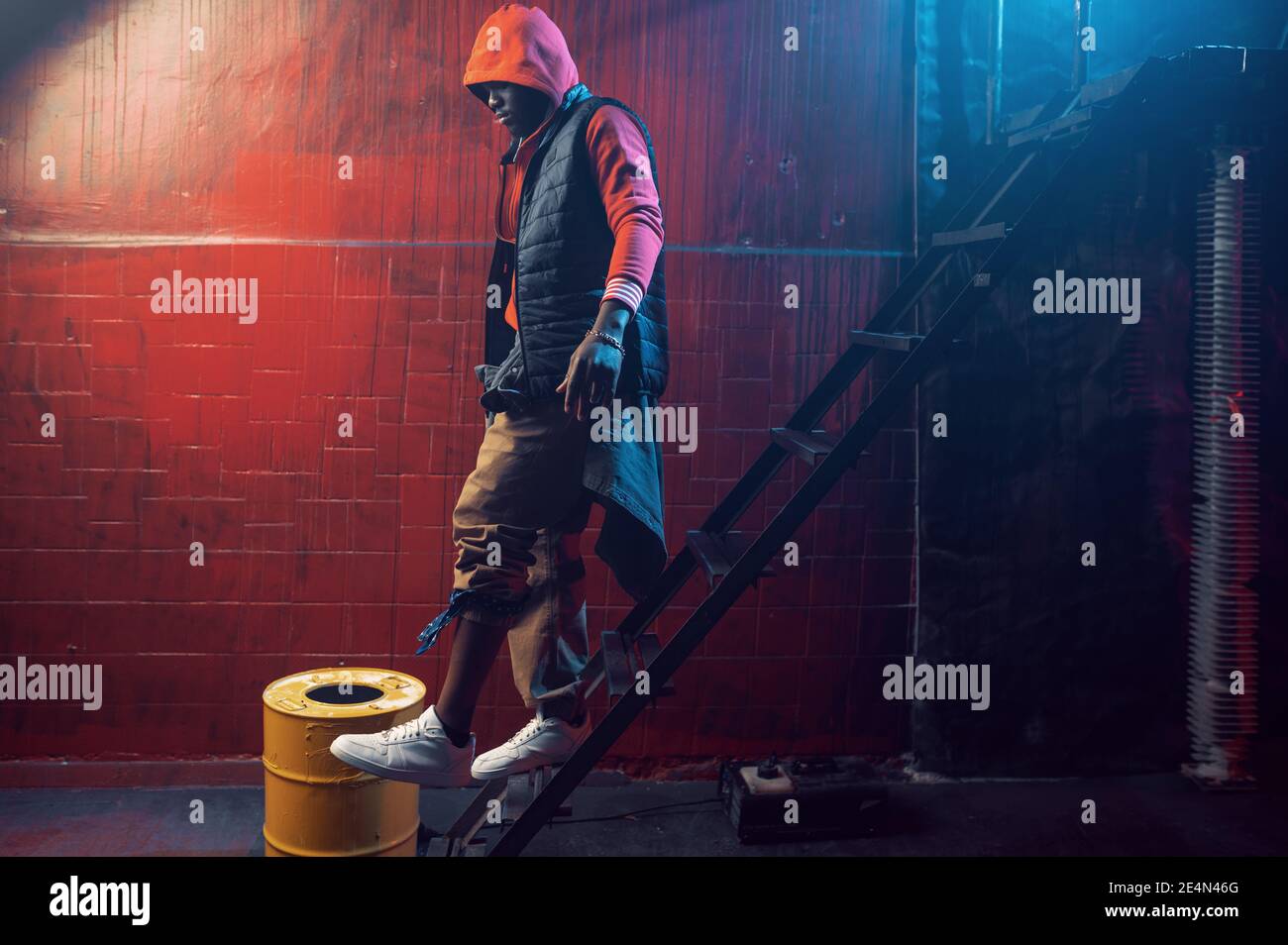 Stylish rapper in hoodie poses in grunge studio Stock Photo - Alamy