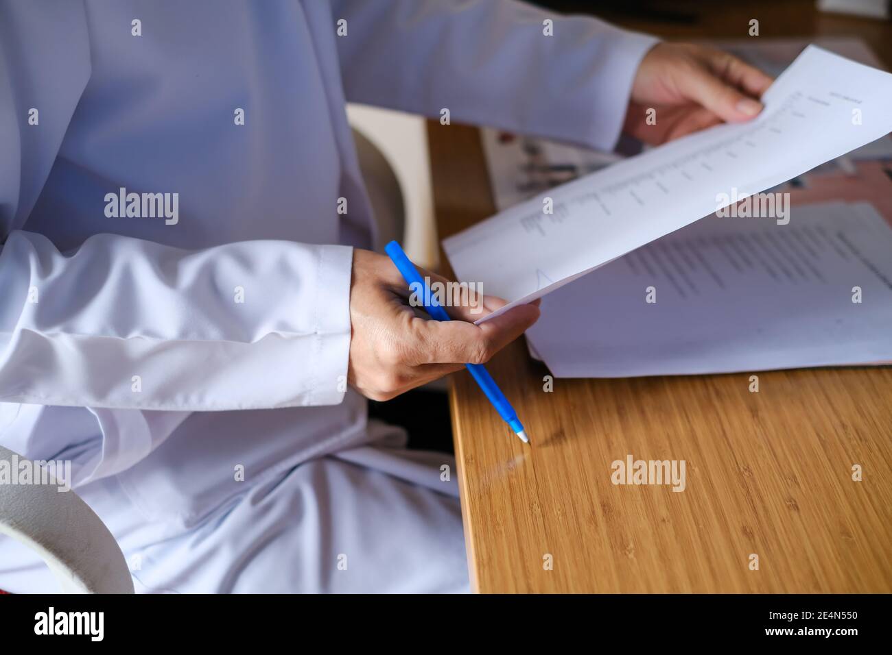 The doctor examines the patient's documents. Side view of doctor hand ...