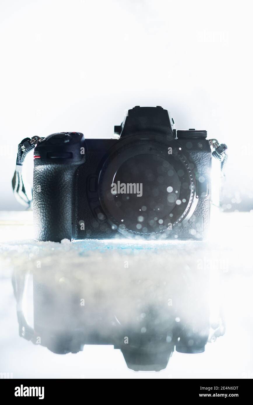 A vertical shot of a reflex camera on a mirror surface isolated on a ...