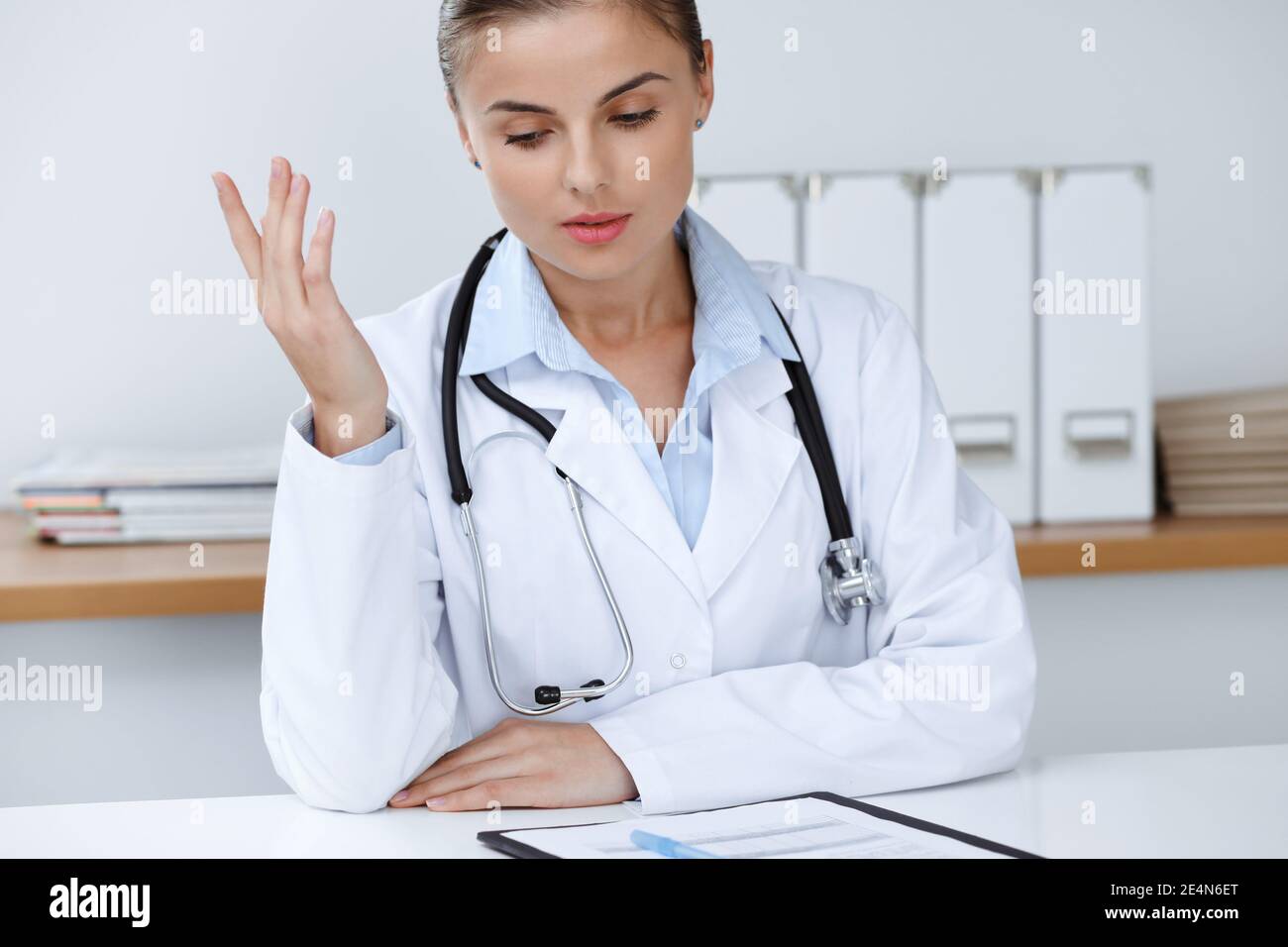 Woman-doctor sitting and working at clinic office. Portrait of female ...