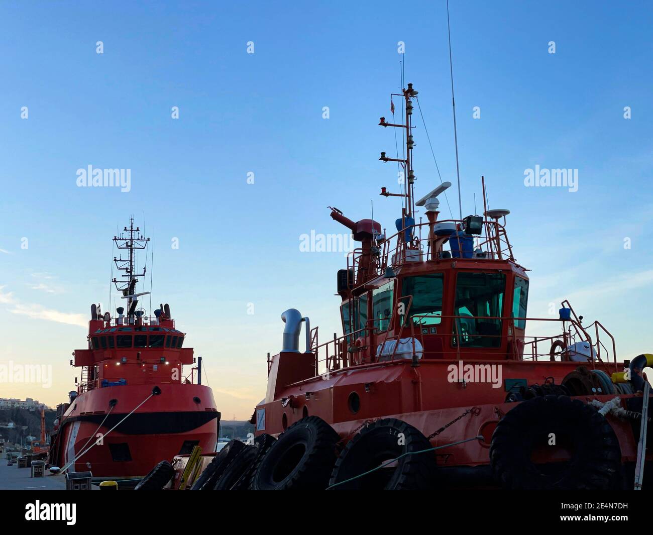 Two red ships in a port under clear sky Stock Photo - Alamy