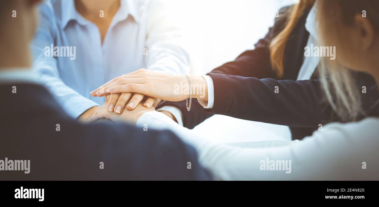 Business team showing unity with their hands together in sunny office ...
