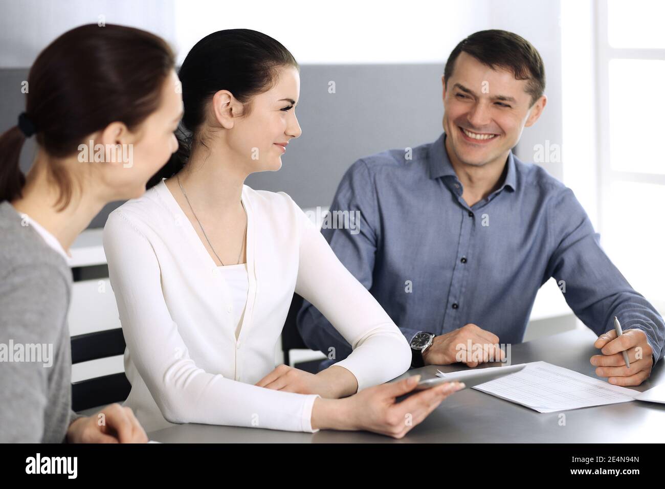 Group of business people discussing questions at meeting in modern ...