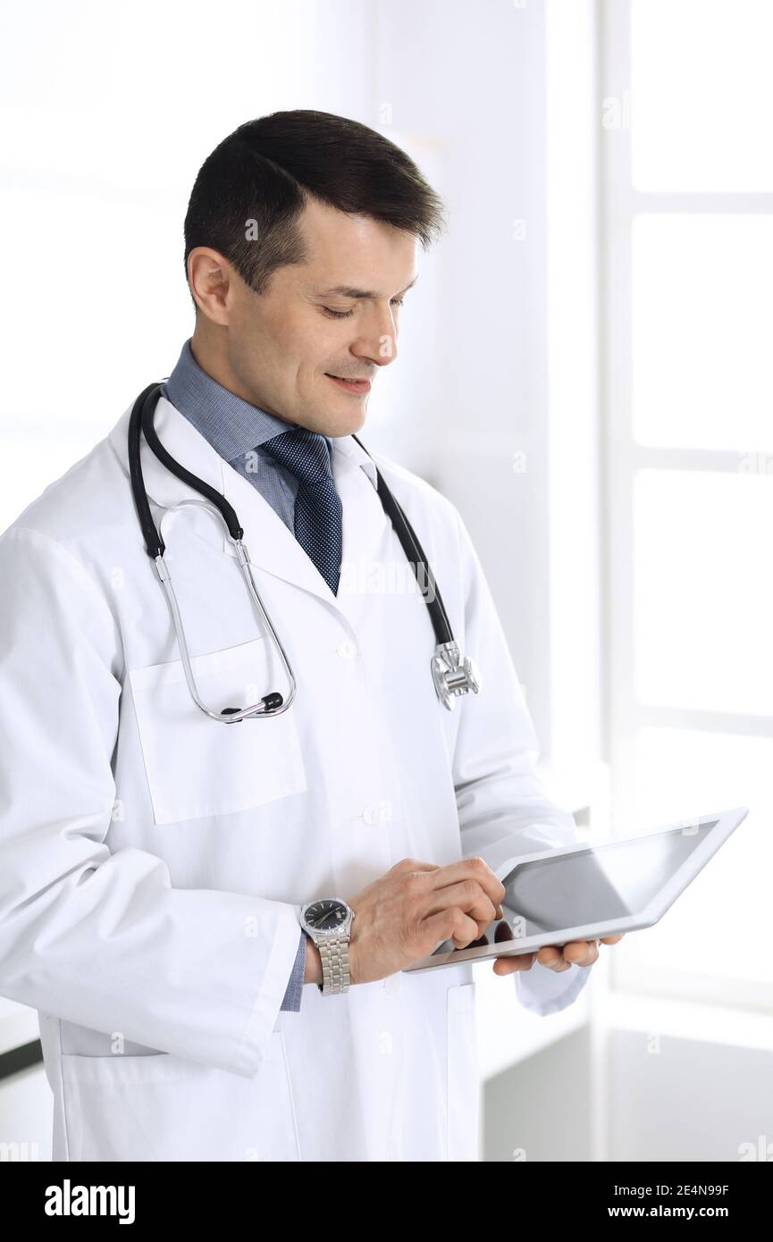 Doctor man using tablet computer for network research or virtual ...