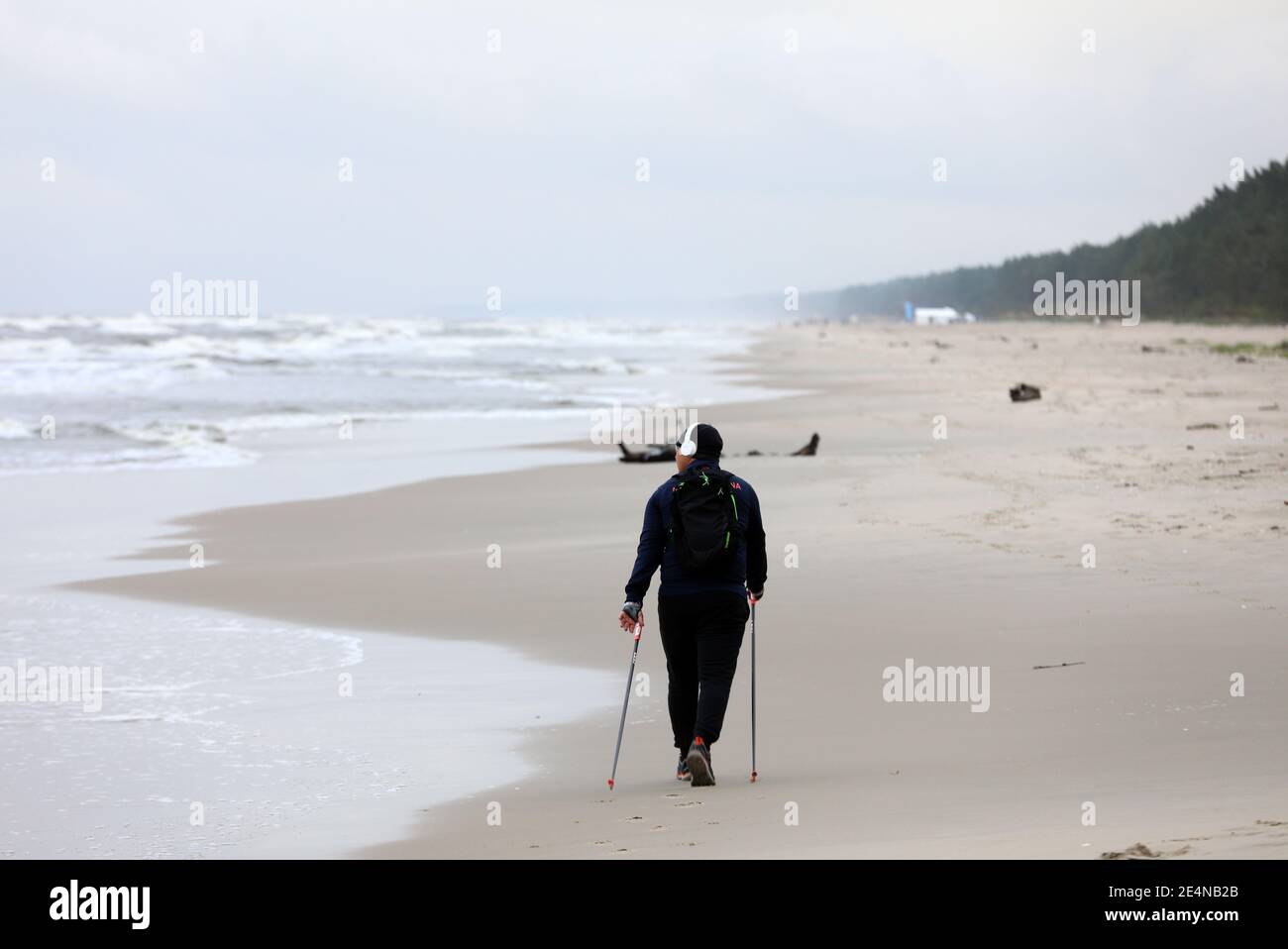 Active and healthy lifestyle. Nordic walking on a sandy beach sea shore ...