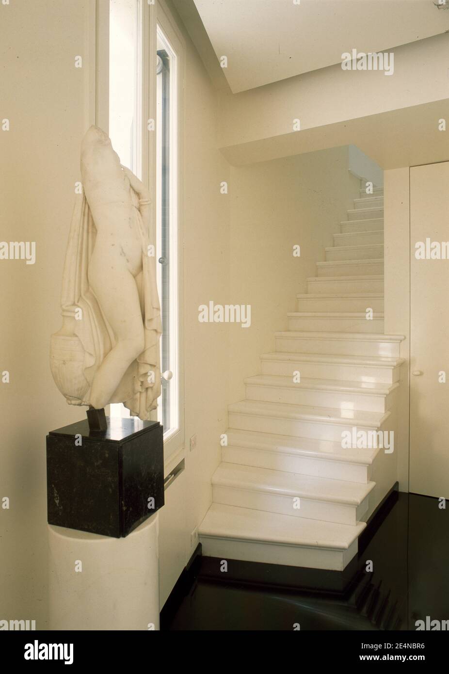 White statue of female model on black plinth in white hallway Stock ...