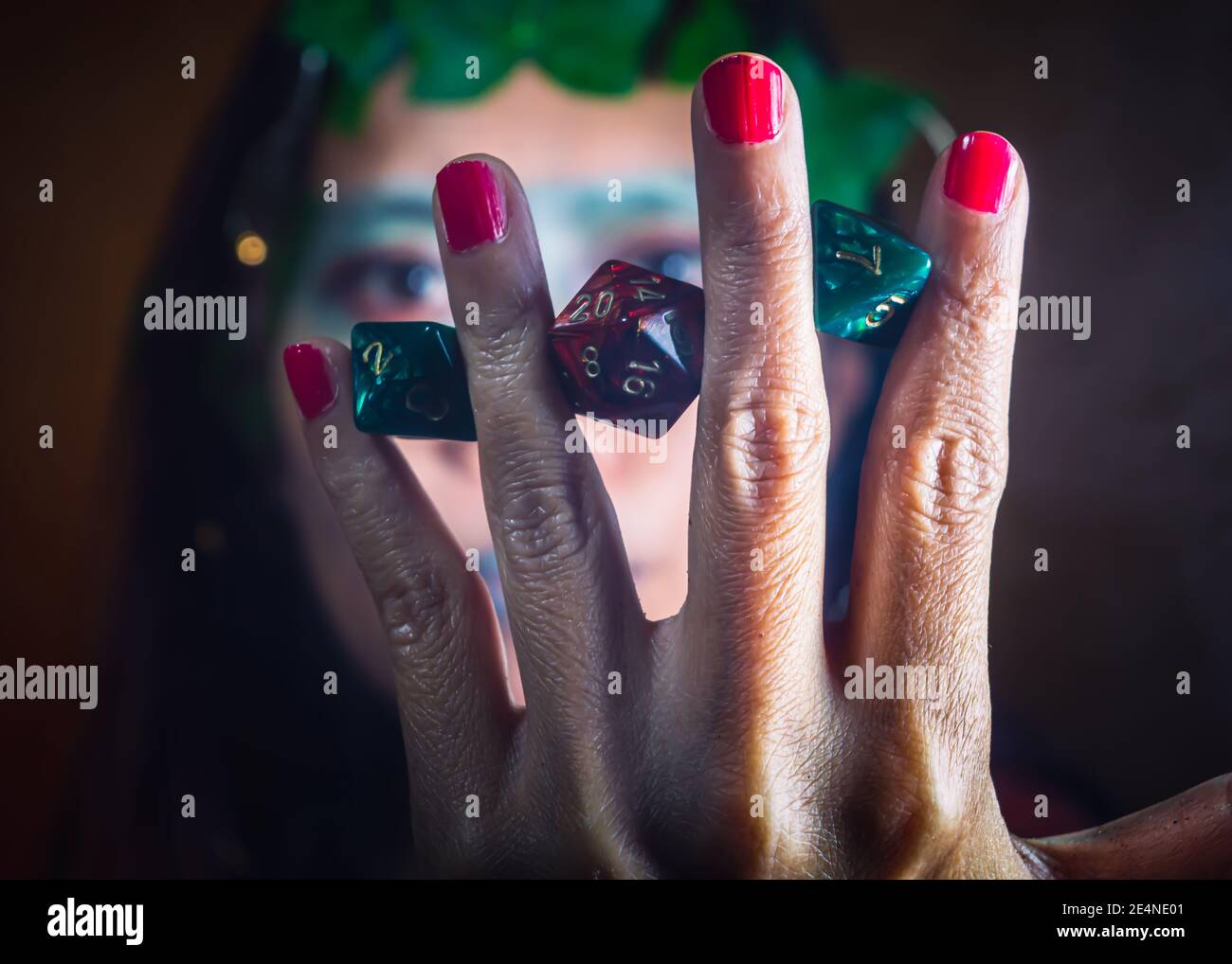 20 sided die and two 8 sided dice hold between the fingers of an Asian ...