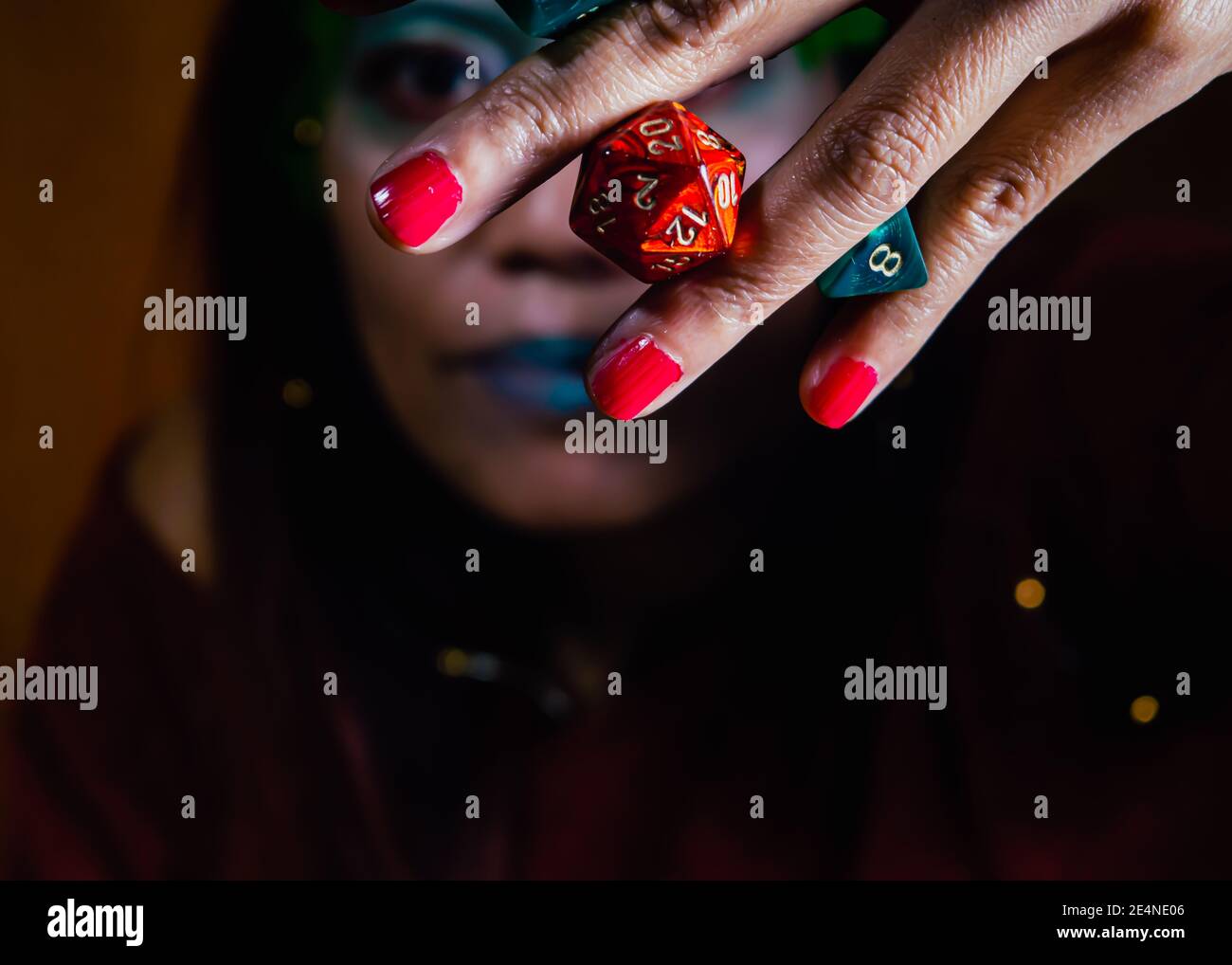 20 sided die and two 8 sided dice hold between the fingers of an Asian ...