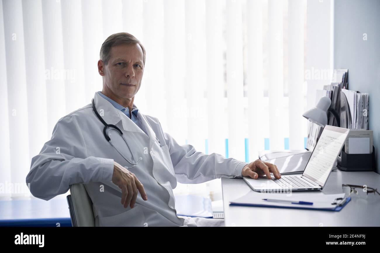 Doctor sitting at desk hi-res stock photography and images - Alamy
