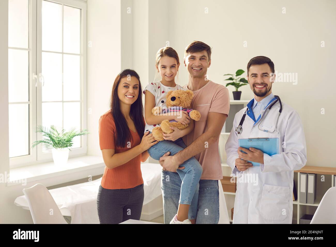 Portrait of smiling young mum, dad and their child together with their ...
