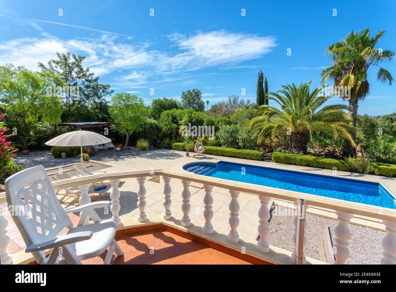 View from the terrace to the luxury pool with clear water in the garden ...