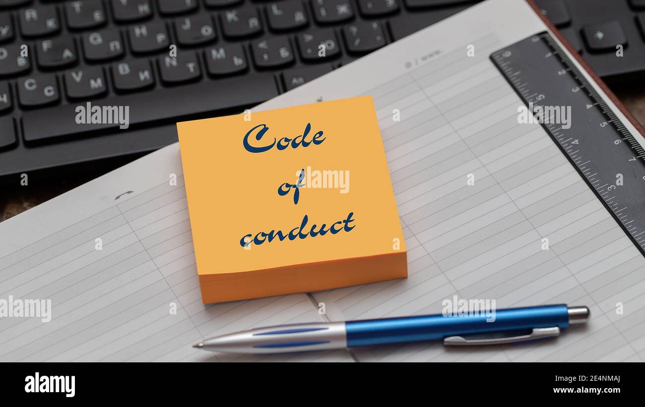 Code Of Conduct written on a yellow reminder sheet on the desk for work ...