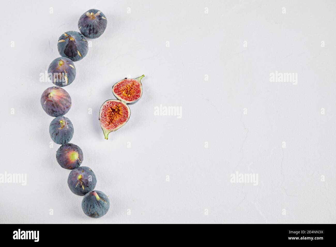 Whole fig and fig slices on a white background Stock Photo - Alamy