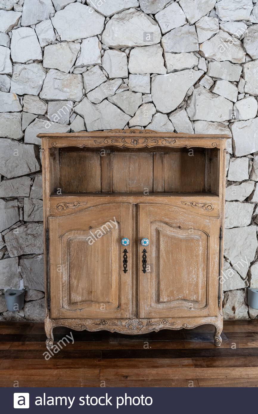 Wooden old small empty cabinet over a stone wall Stock Photo - Alamy