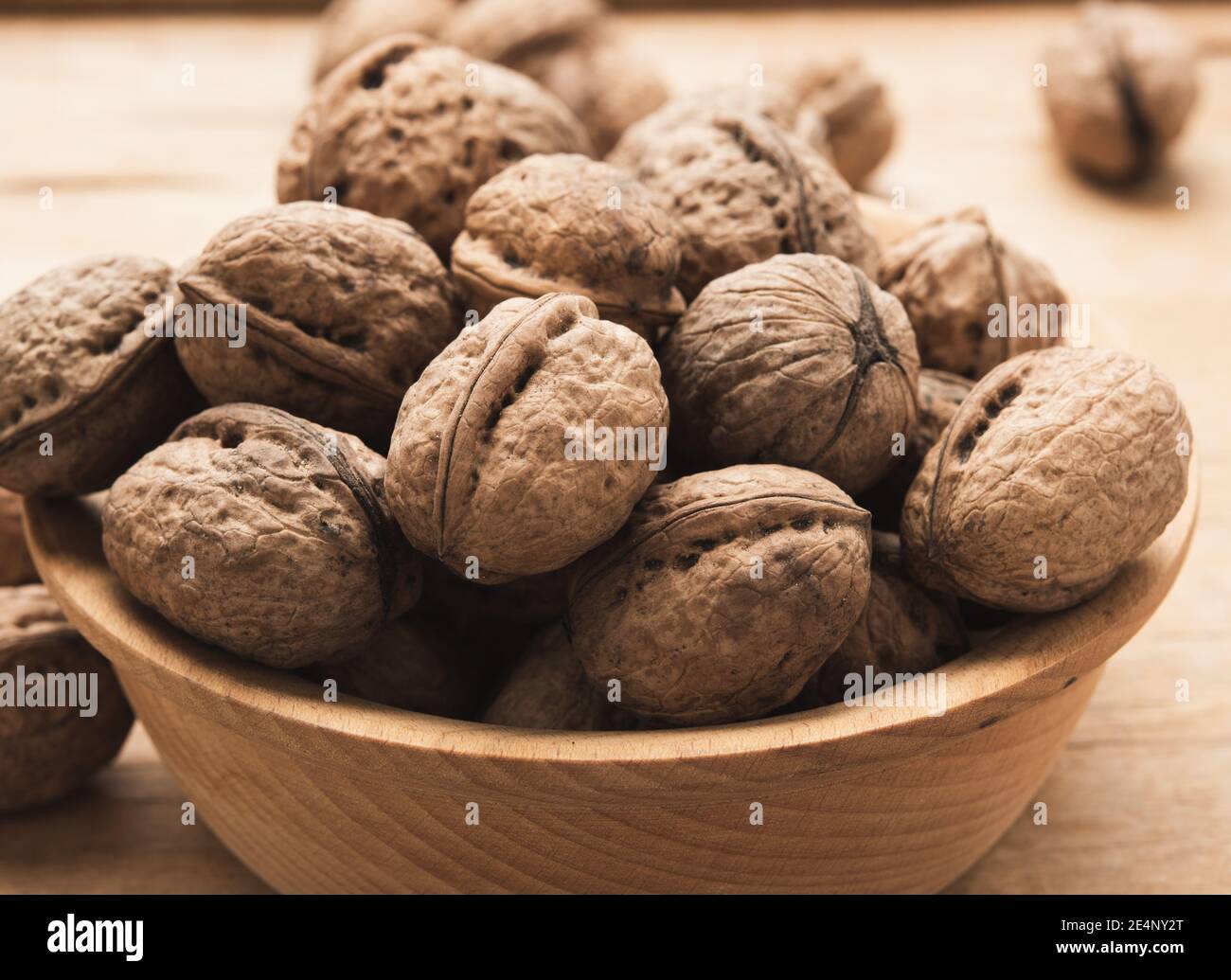 bunch of walnuts in a wooden plate on the table, close up Stock Photo ...
