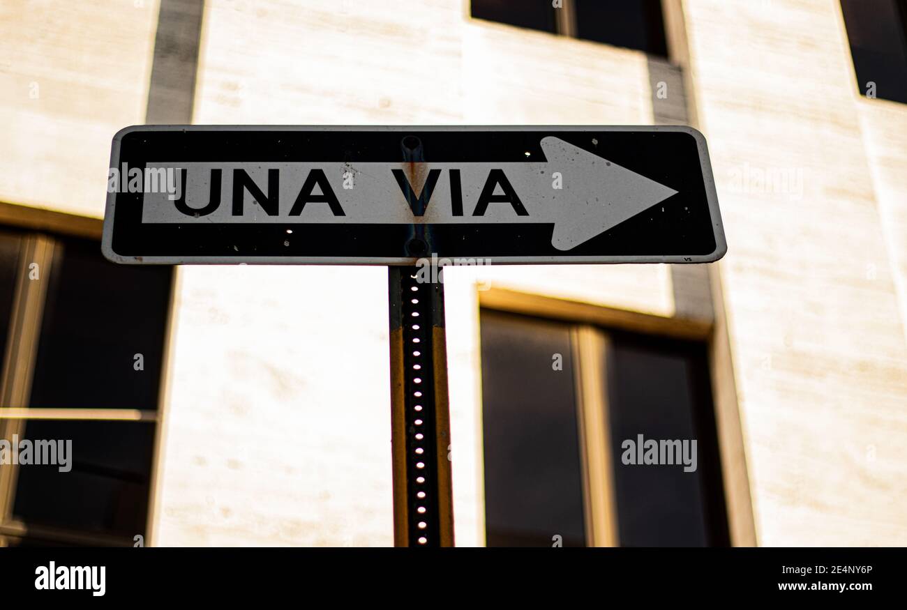 A traffic sign meaning One Way with a building in the background Stock ...