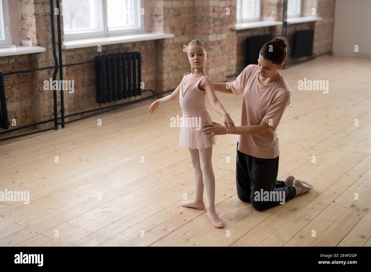 Little girl learning to stand in right position during her ballet ...