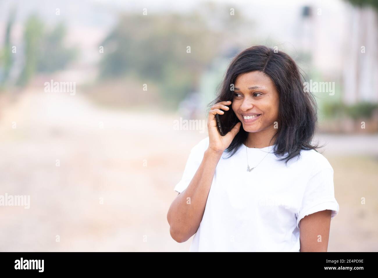 beautiful young african woman smiling while making a phone call outdoor ...