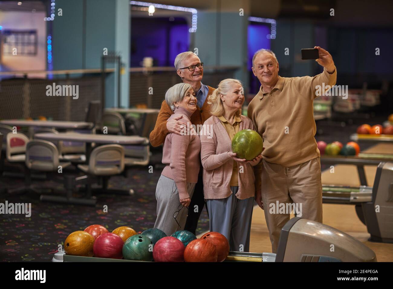 Wide angle view at group of senior people taking selfie photos playing ...