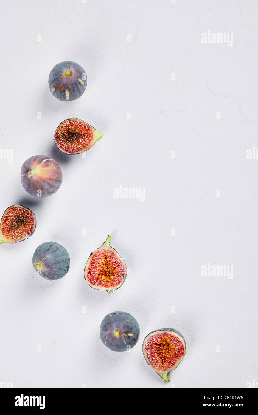 Whole fig and fig slices on a white background Stock Photo - Alamy