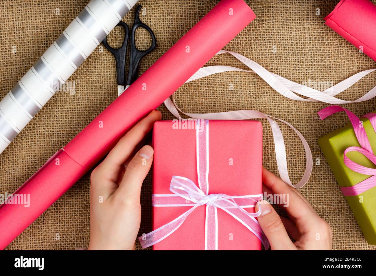 Gift wrapping process. View from above. Women's hands are packing a ...