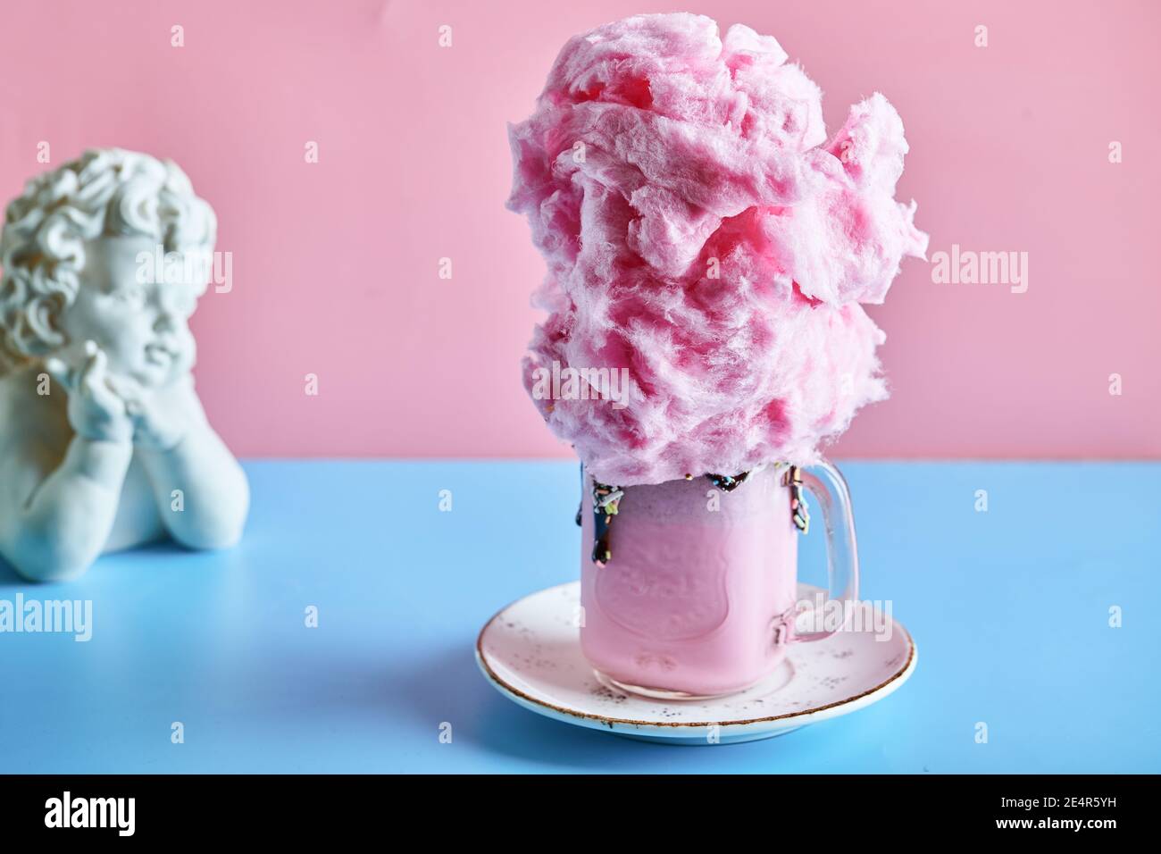 Milkshake with bubble gum in the ceramic plate on the pink background ...