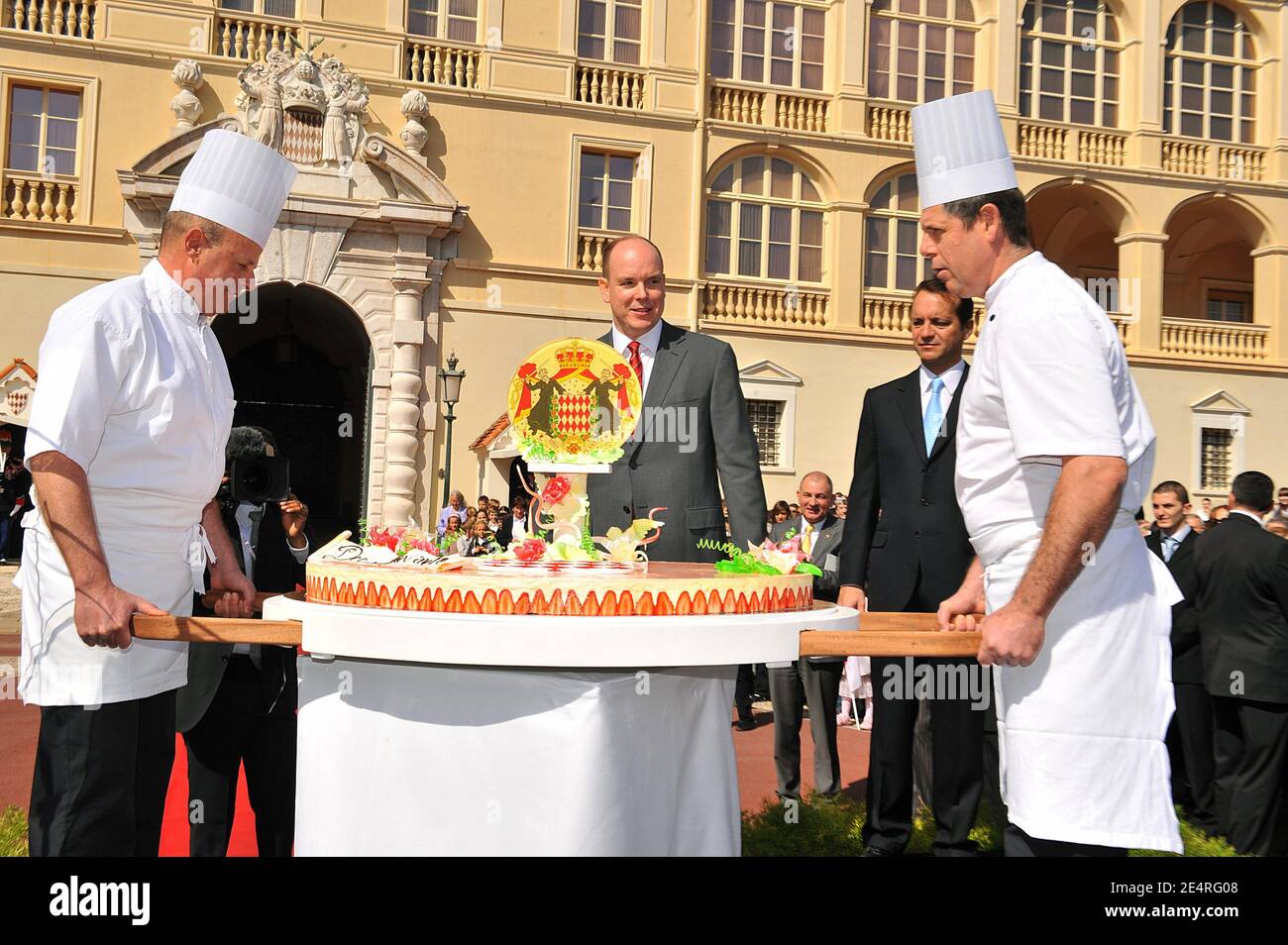 A giant birthday cake is carried in front of Prince Albert II of Monaco ...