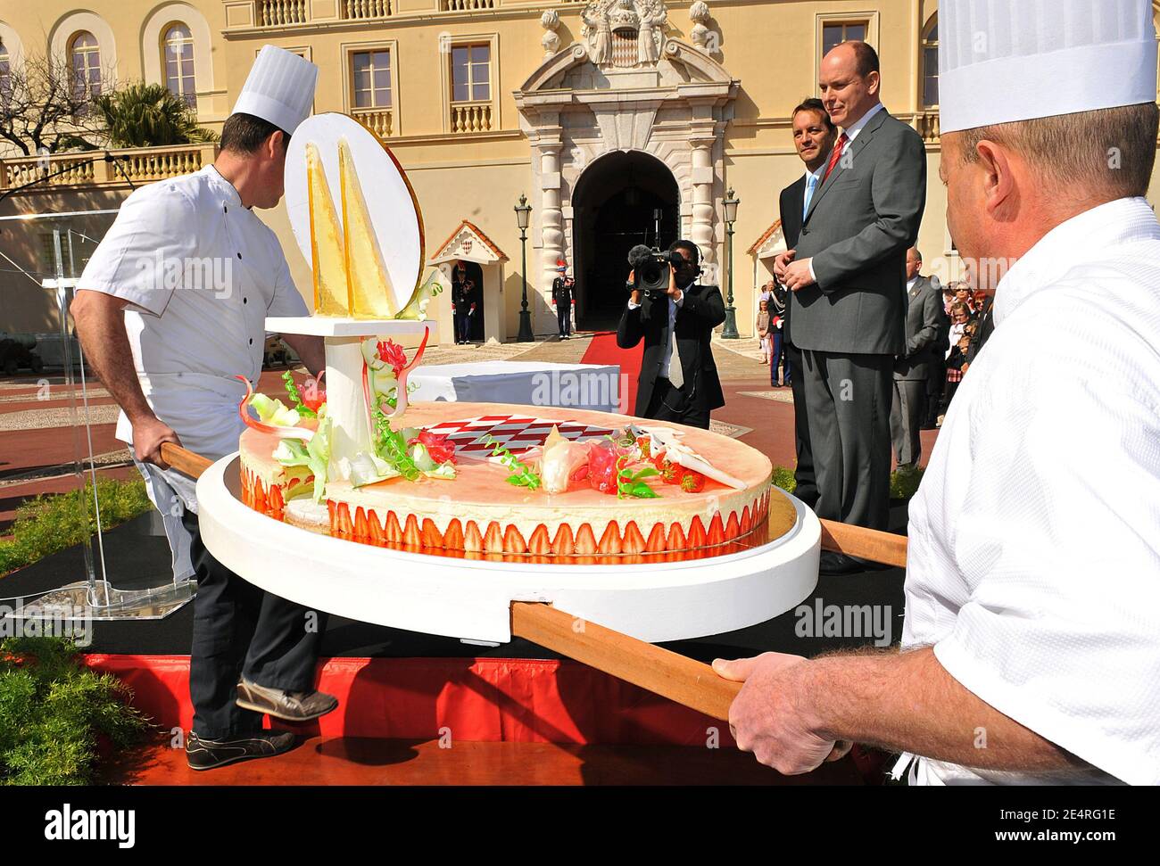 A giant birthday cake is carried in front of Prince Albert II of Monaco ...