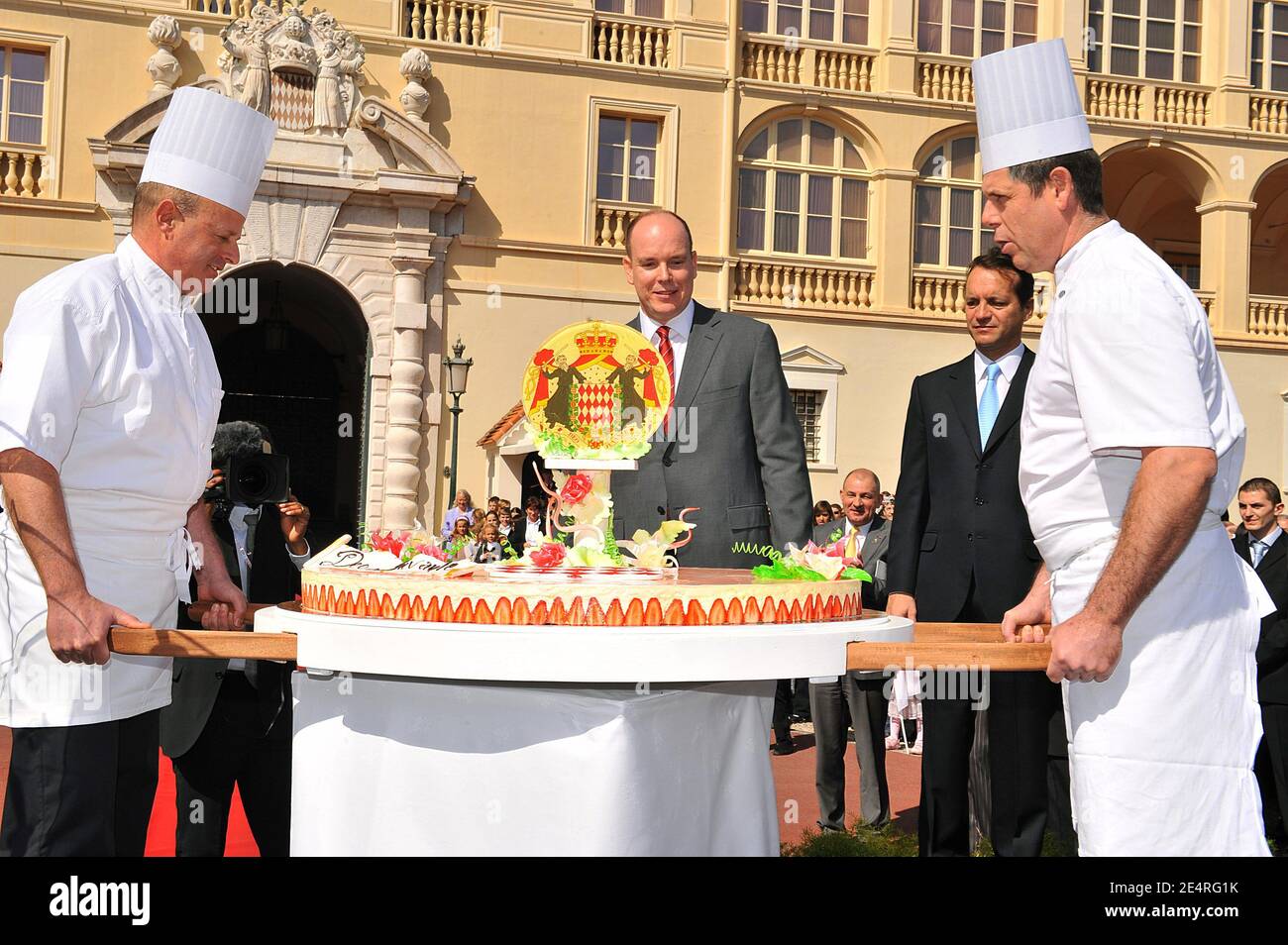 A giant birthday cake is carried in front of Prince Albert II of Monaco ...
