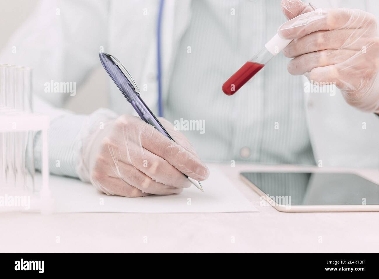 Unrecognizable doctor wearing rubber gloves and white coat working with ...