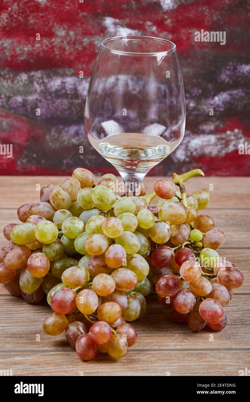 Green grapes with an empty wine glass around Stock Photo - Alamy