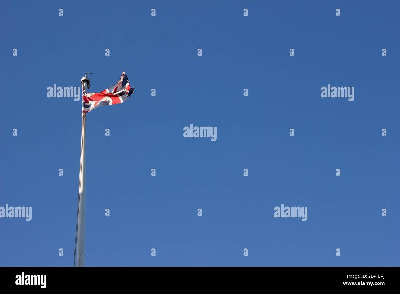 Union flag flying high in the blue sky Stock Photo - Alamy