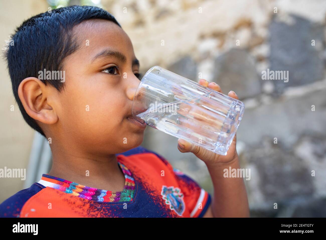 A child drinks a glass of clean water in San Juan la Laguna, Guatemala ...