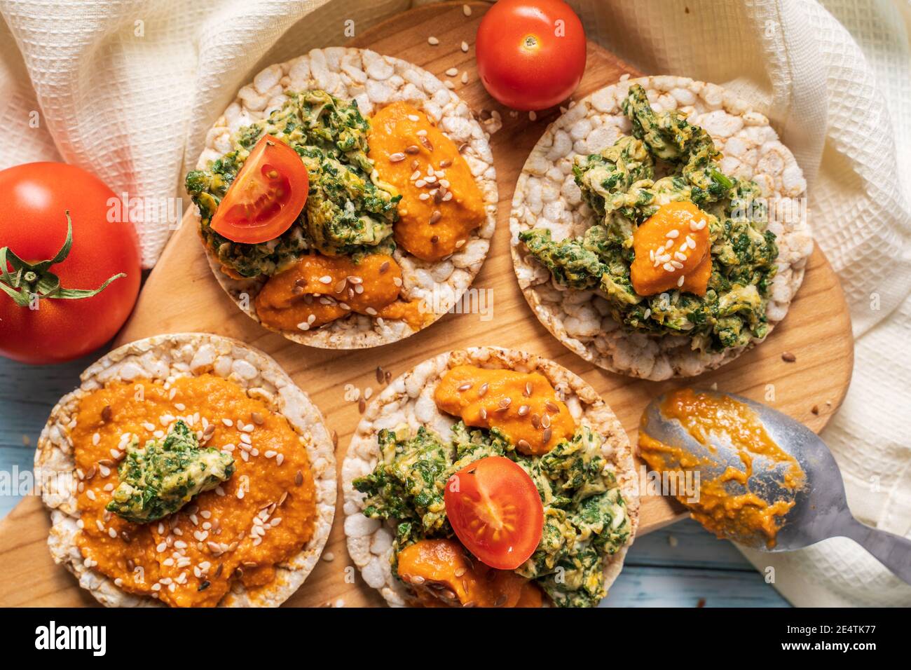 Crispy puffed rice cakes on table with hummus spread spinach with eggs ...