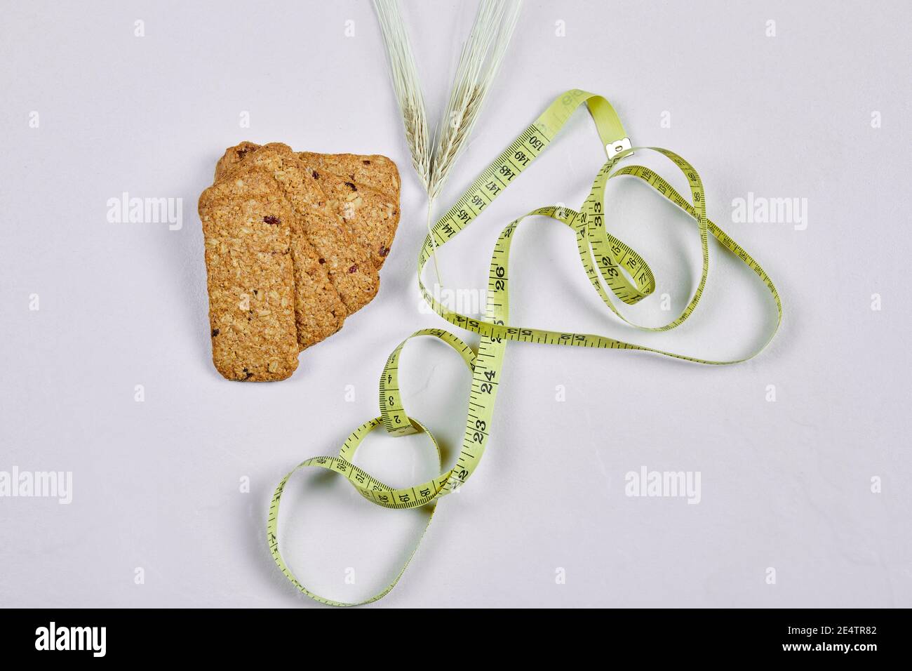 Biscuits and tape measure on a white background Stock Photo - Alamy