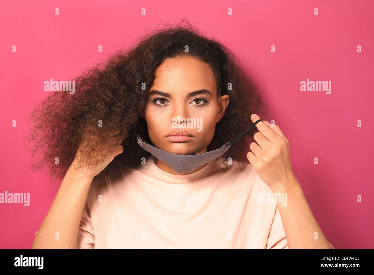 No emotion or indifference holding reusable mask African American girl ...