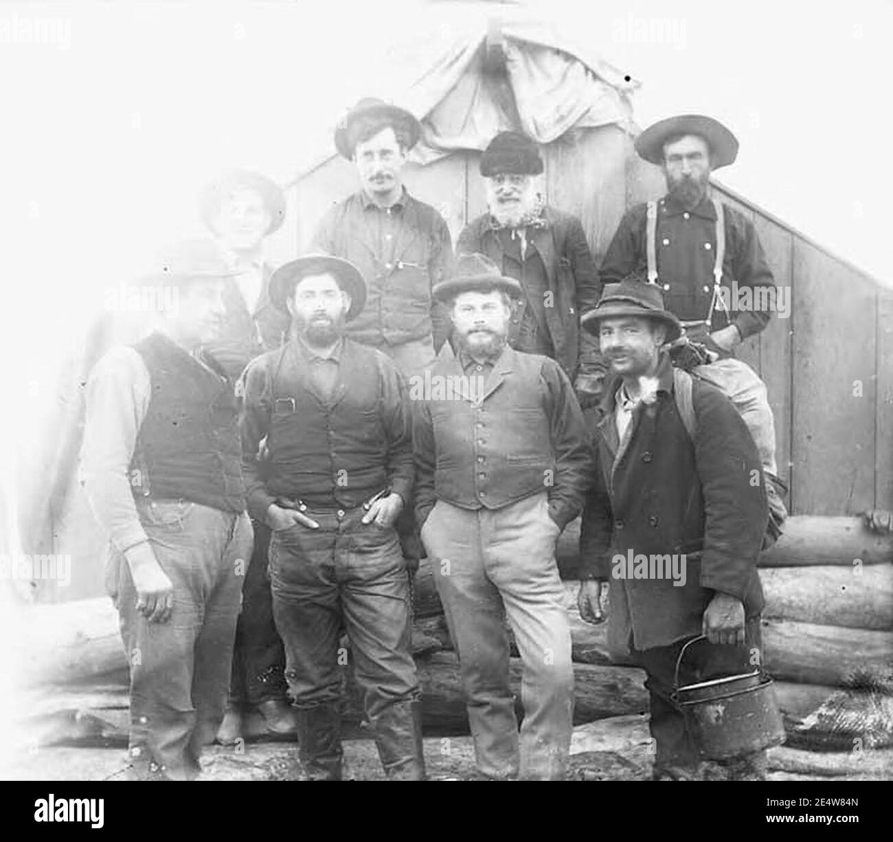 Men pose at Tom Arsh cabin, including John Heston, Al Osborn, Bartie Osborn, Billie McKenna and ...