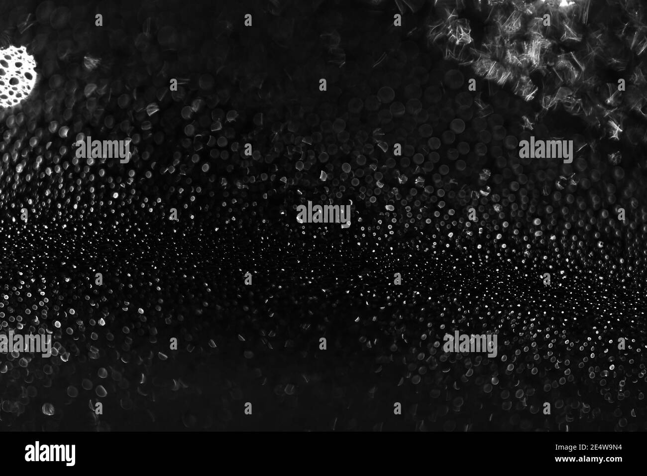 Water droplets on glass at night, dark background. Black and white ...