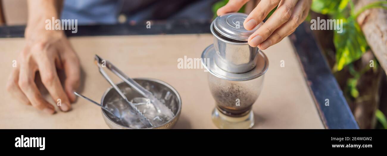 Caucasian man and traditional drip brewed Vietnamese coffee from a phin ...