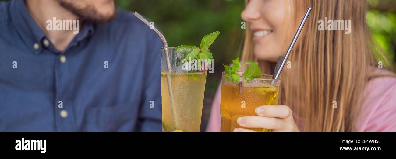 Eco friendly couple using reusable stainless steel straw to drink fruit ...