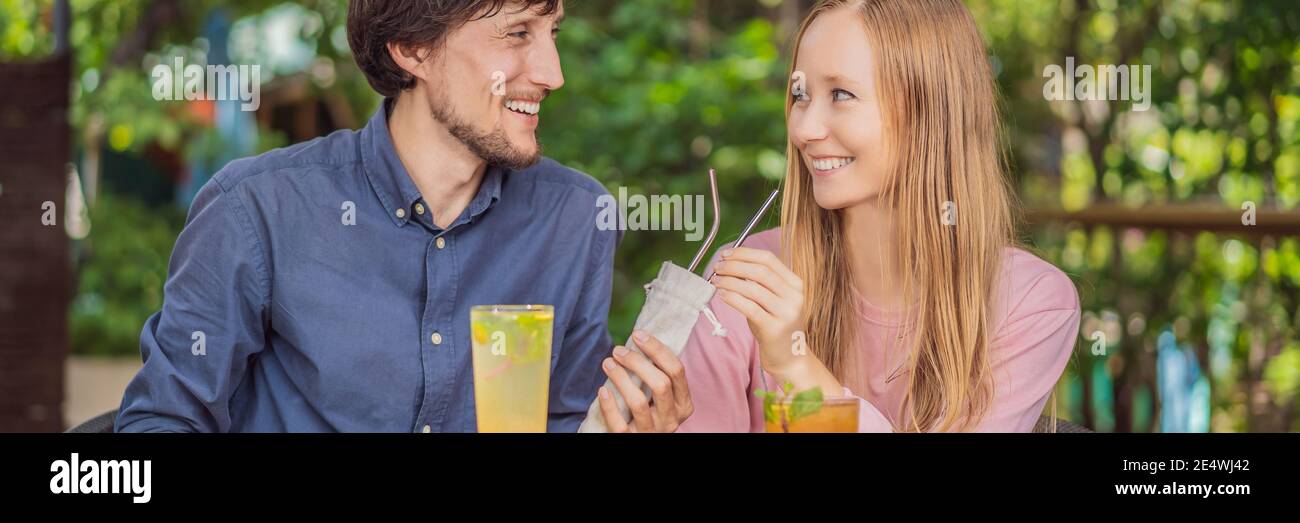 Eco friendly couple using reusable stainless steel straw to drink fruit ...