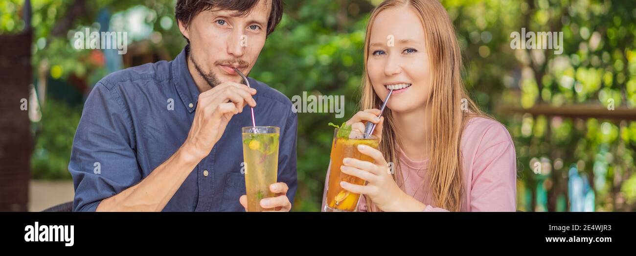 Eco friendly couple using reusable stainless steel straw to drink fruit ...
