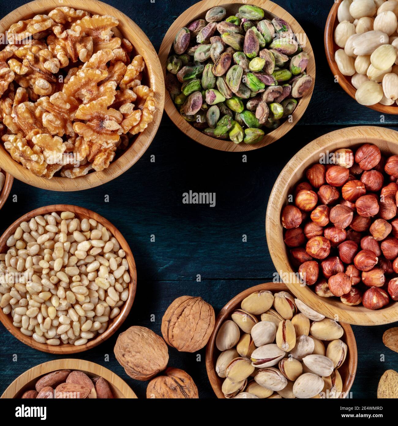 Nuts variety square design template. Various nuts in wooden bowls ...