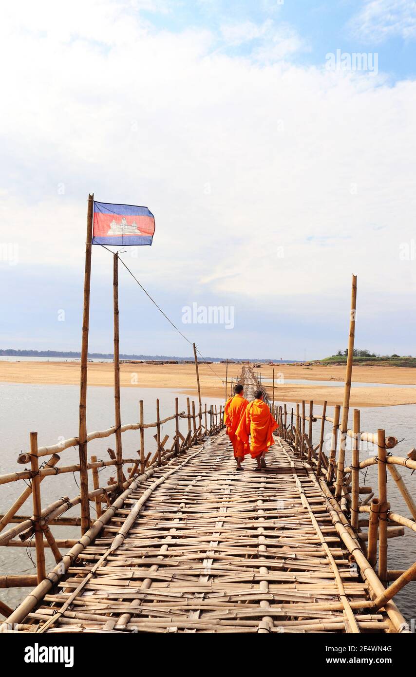 Two buddhist monks on bamboo bridge across Mekong river between Kampong ...