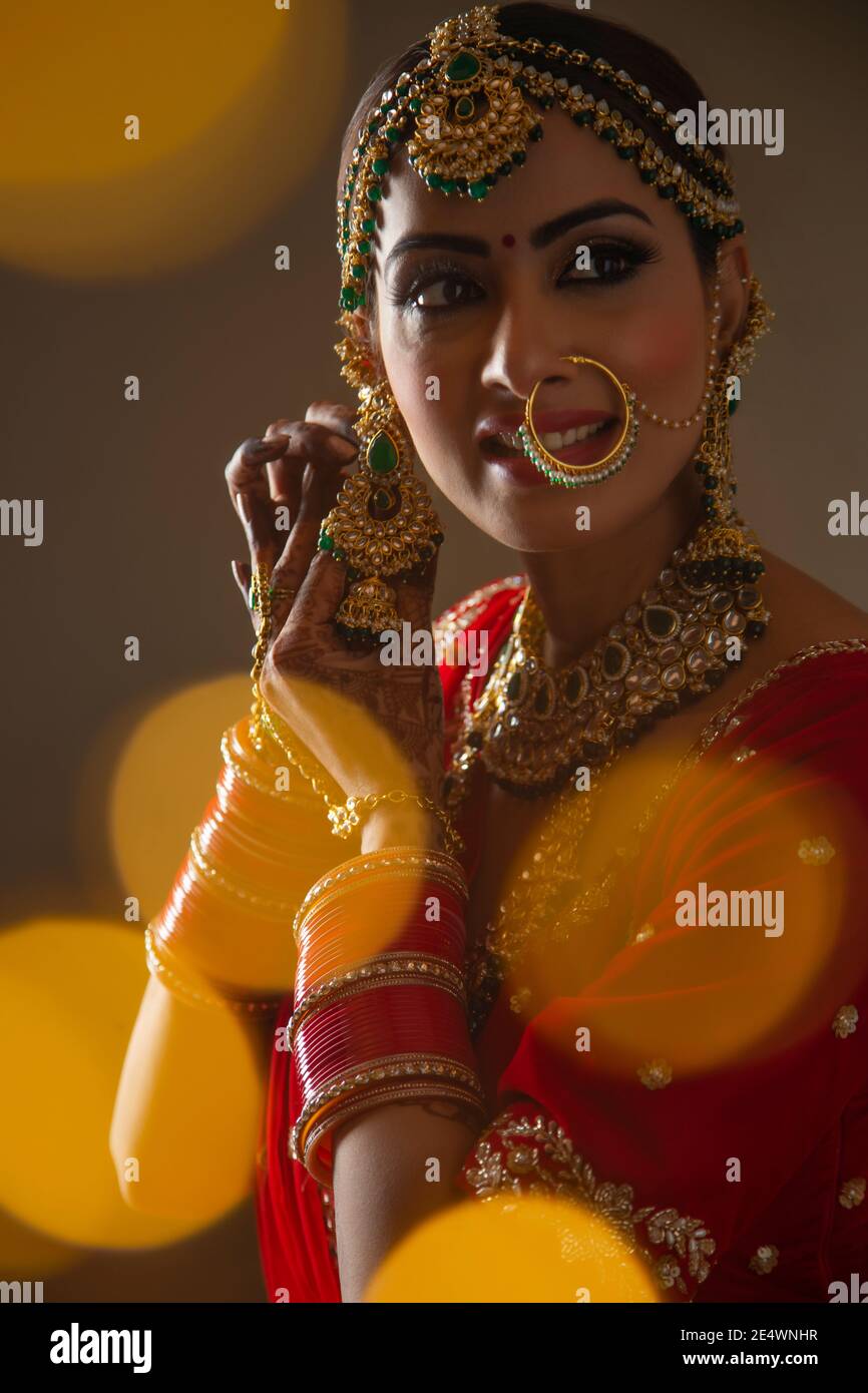Beautiful Indian Bride, adjusting her earing Stock Photo - Alamy