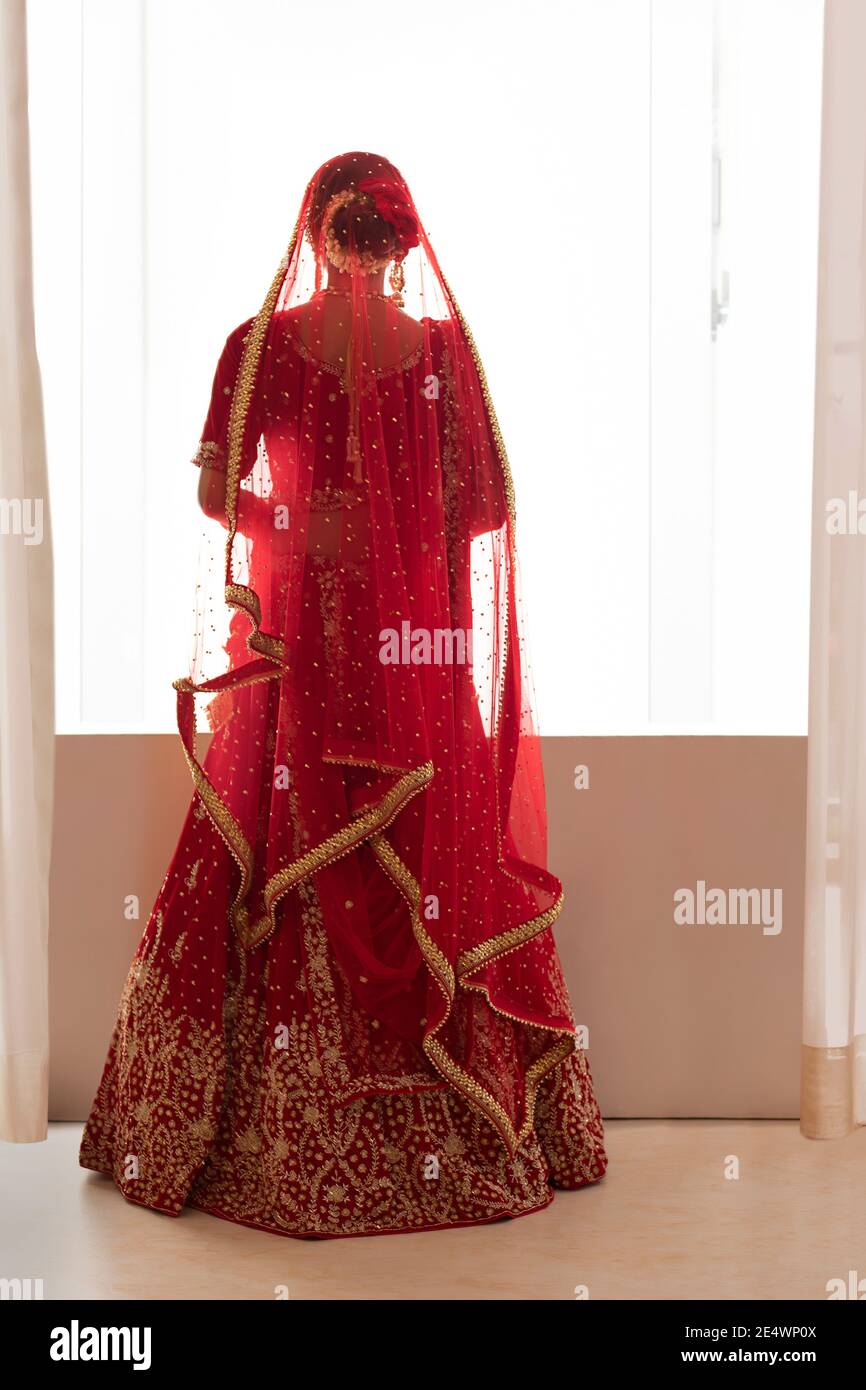 Indian bride standing on the window looking down Stock Photo - Alamy
