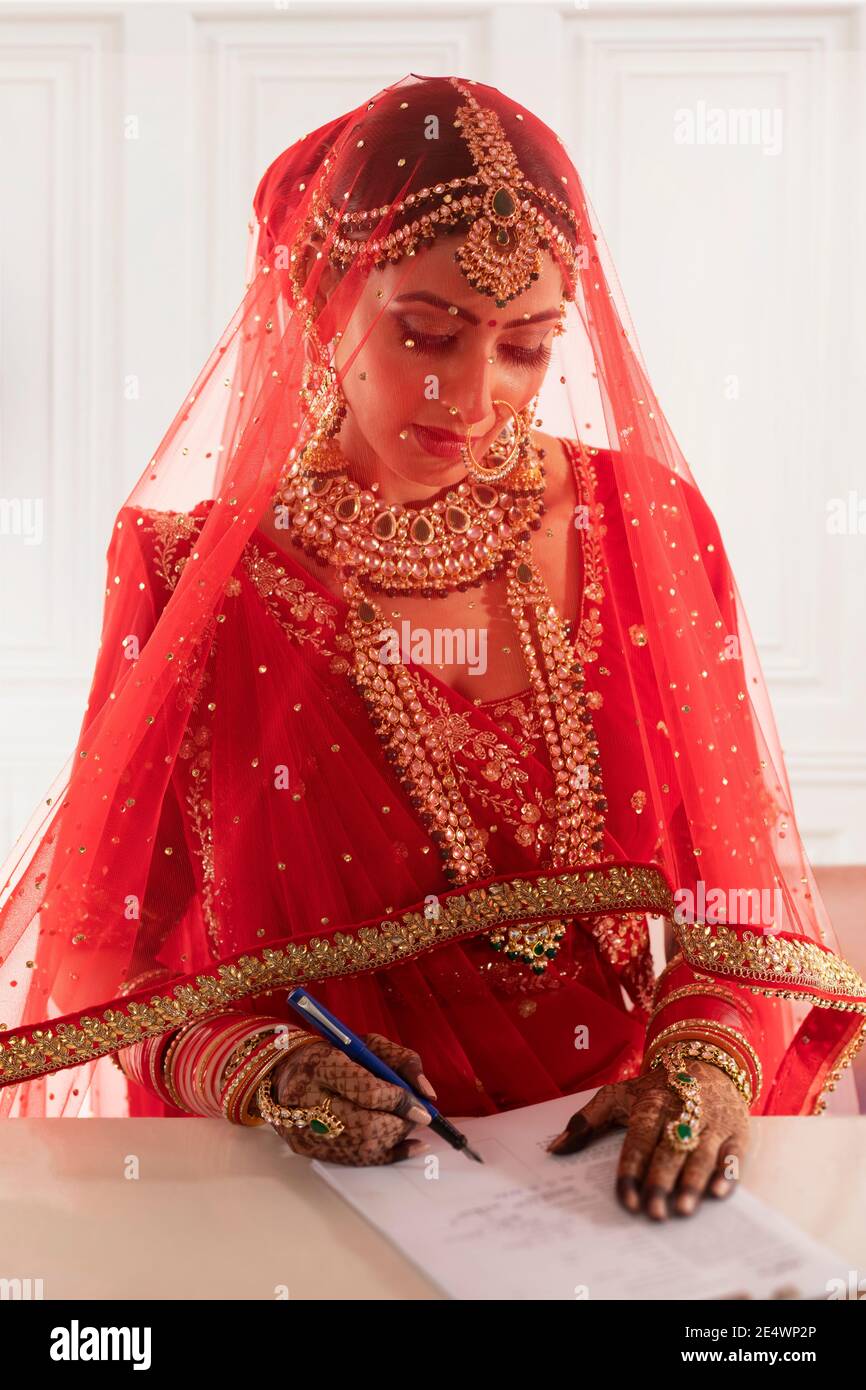 Indian bride signing wedding documents Stock Photo - Alamy