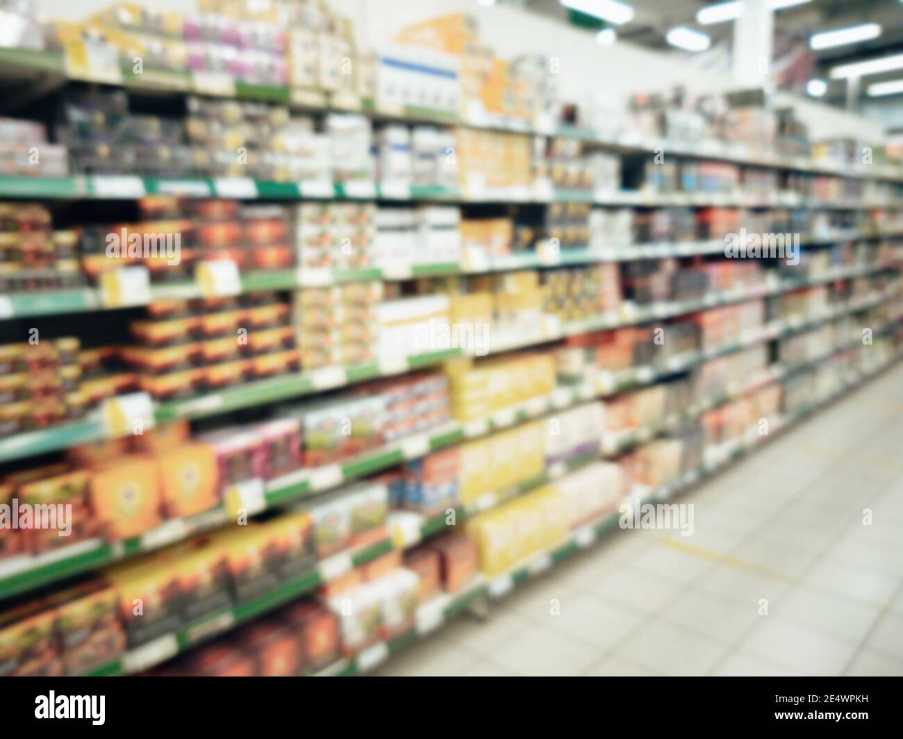 Blurred supermarket aisle with colorful food shelves of merchandise ...